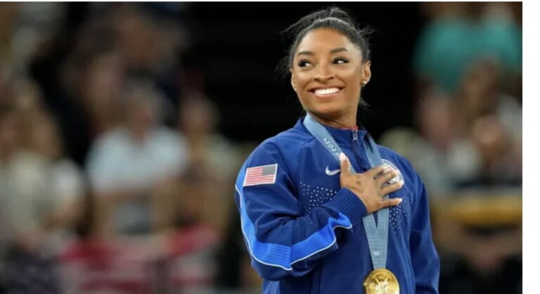 Simone Biles celebrates her gold medal with a diamond goat necklace